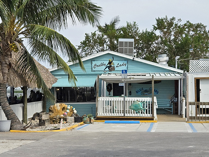 The turquoise beacon of Crabby Lady stands out against Florida's palms like a delicious mirage, promising seafood treasures within its cheerful walls.