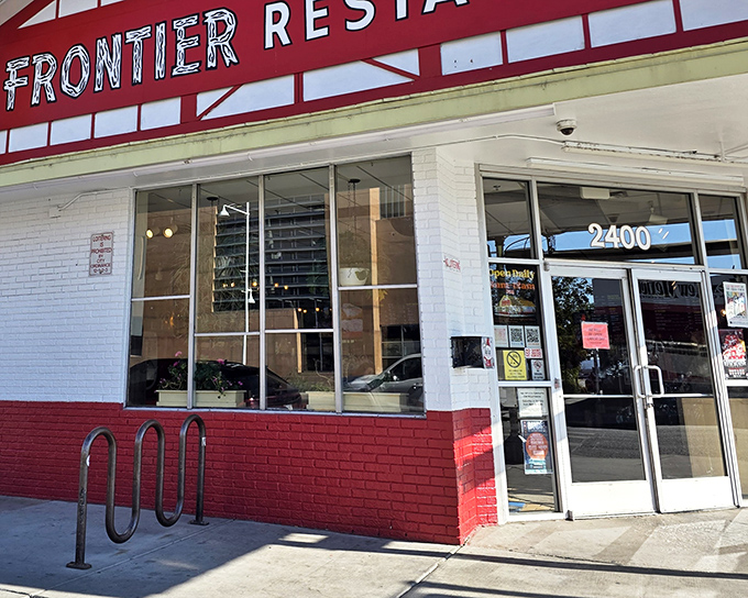The iconic red and white facade of Frontier Restaurant stands like a beacon for hungry souls across from UNM, promising salvation in the form of green chile.