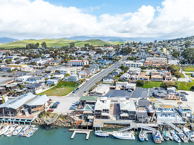 The charming town of Morro Bay sprawls beneath rolling green hills, where coastal living meets small-town charm in a postcard-perfect California setting.