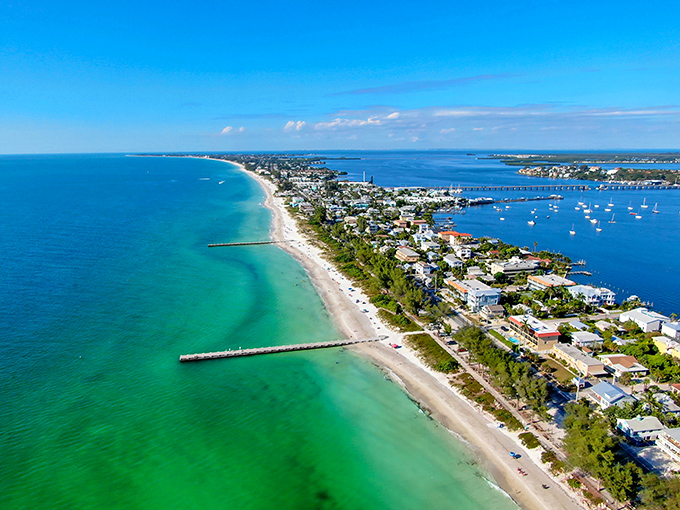 Anna Maria's coastline stretches like nature's perfect smile, where emerald Gulf waters meet powdery white sand on one side and tranquil bay views on the other.