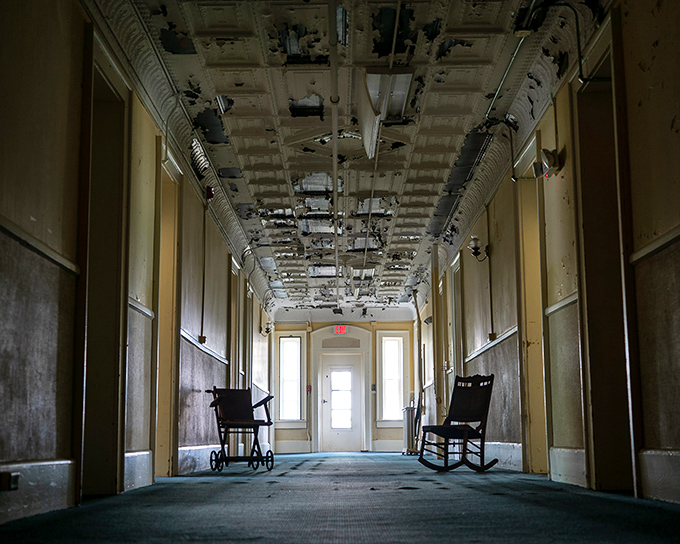 The infamous corridor where time stands still. Abandoned wheelchairs and rocking chairs wait patiently for occupants who checked out decades ago.