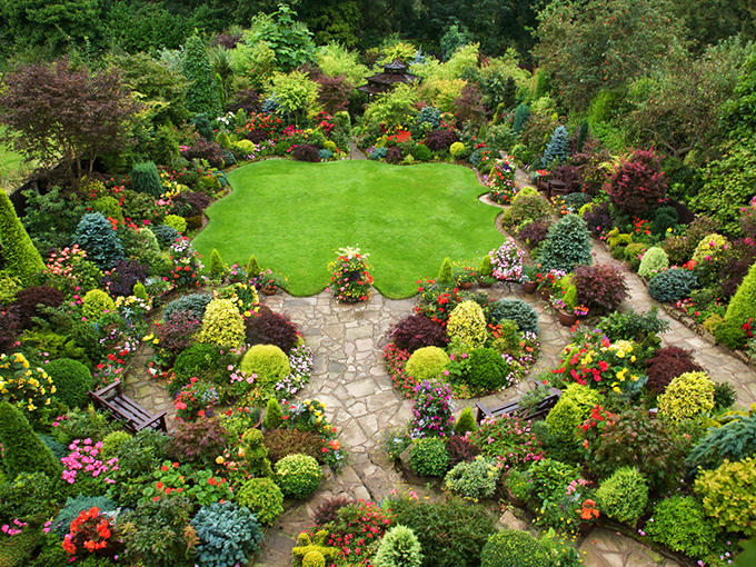Nature's perfect amphitheater: a verdant circular lawn embraced by a kaleidoscope of perennials, proving that Mother Nature might secretly be an interior designer.