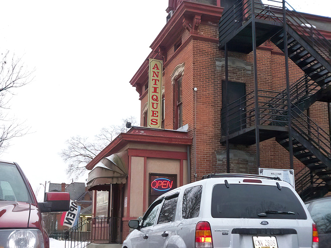 The brick facade of the Greater Columbus Antique Mall rises like a time portal on South High Street, inviting treasure hunters inside with its glowing sign and old-world charm.