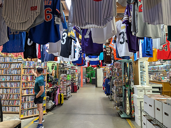 Sports memorabilia heaven awaits inside, where jerseys hang like championship banners above aisles packed with collectibles and media treasures.
