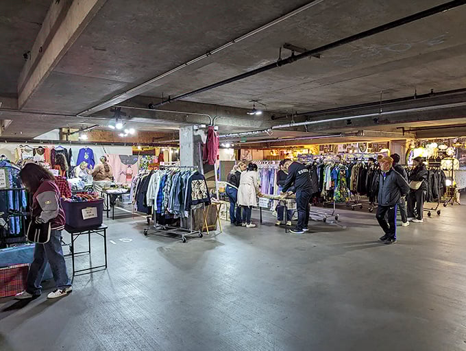 Treasure hunters navigate the indoor section of Fremont Market, where vintage clothing racks create a labyrinth of potential discoveries waiting to be unearthed.