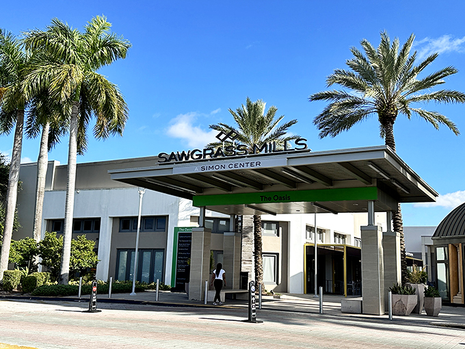 Another view of Sawgrass Mills' welcoming entrance, where the Simon Center sign promises a day of retail therapy under swaying palms and blue skies.