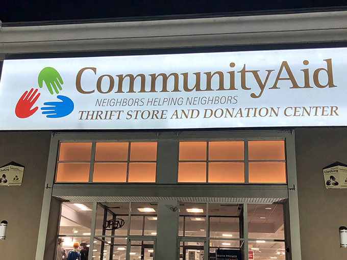 The welcoming facade of CommunityAid beckons with its colorful handprint logo—like a high-five promising bargains inside.