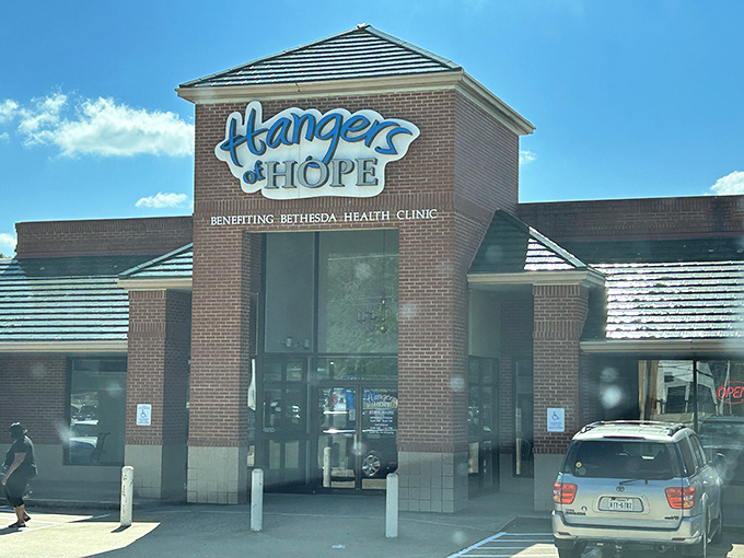 The cheerful blue sign of Hangers of Hope welcomes bargain hunters like a beacon of thrifty possibility against the Texas sky.