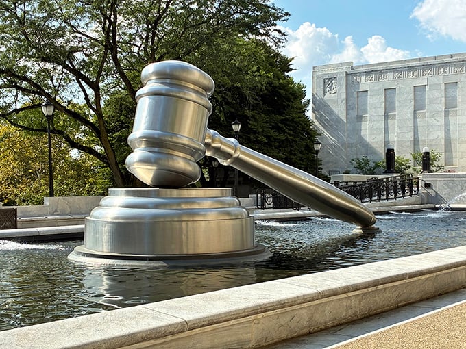 Justice makes a splash! The mighty gavel sits partially surrounded by water, reflecting both the sky and the weighty responsibility of the legal system.