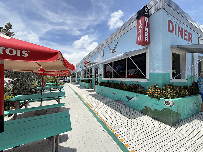The turquoise-trimmed exterior of Lighthouse Diner stands like a cheerful beacon for hungry travelers. Those teal picnic tables practically beg you to linger.