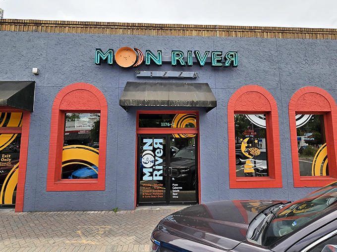 Daylight reveals Moon River's cheerful exterior, where the bright red-trimmed windows frame glimpses of pizza paradise waiting inside.