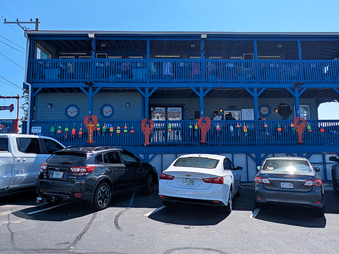 The iconic blue exterior of Ray's Seafood stands out like a maritime flag, complete with colorful buoys that promise authentic New England seafood treasures await inside.