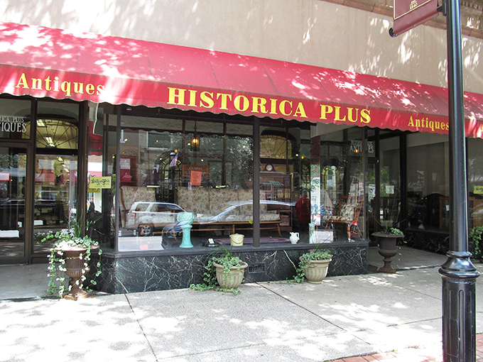 Sunlight dapples the storefront where yesterday's furniture waits for tomorrow's homes. That display window has probably convinced more spouses to "just stop for a minute" than any sales pitch.