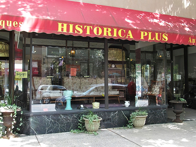 The iconic red awning of Historica Plus beckons like a portal to the past, promising treasures beyond the glass.