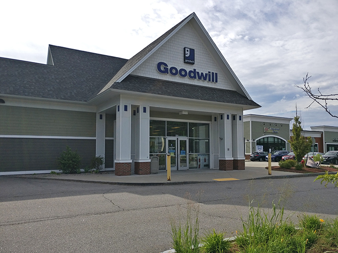 The iconic blue Goodwill sign beckons like a lighthouse for bargain hunters, promising treasures waiting to be discovered inside this Somersworth gem.
