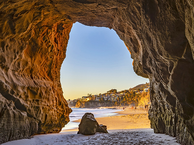 Paradise found! The golden crescent of 1000 Steps Beach stretches beneath luxury homes perched on sandstone cliffs, nature's perfect balancing act.