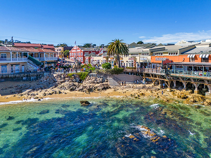 Cannery Row's vibrant waterfront showcases nature's perfect marriage with commerce&mdash;crystal clear waters meeting historic buildings where otters and tourists alike find their happy place.