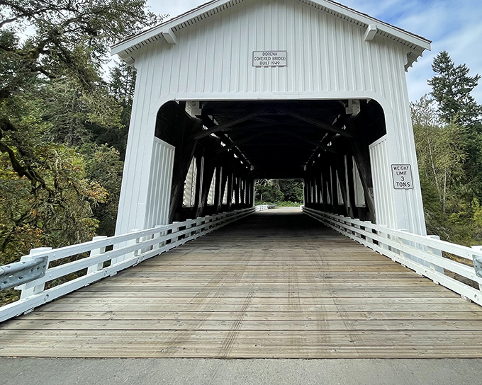 The pristine white façade of Dorena Covered Bridge stands like a time portal to simpler days, inviting travelers to slow down and savor the journey.