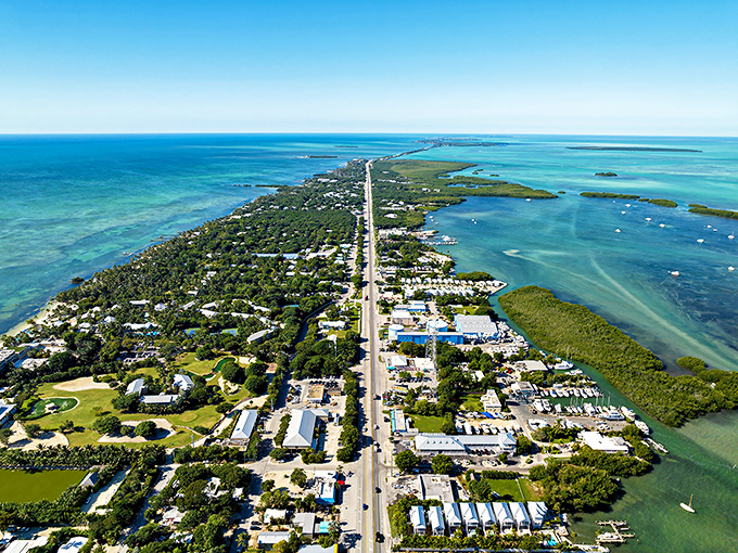 Aerial paradise where the Overseas Highway threads through this slender island like a lifeline, connecting patches of civilization amid stunning turquoise waters.