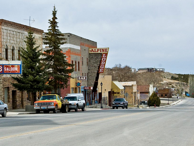 The Alpine Lodge sign stands tall among historic storefronts, a sentinel of small-town hospitality since frontier days.