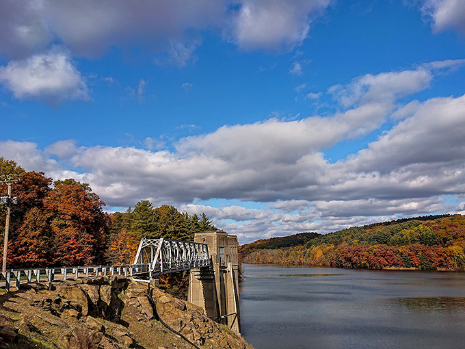 Pleasant Hill Dam creates this postcard-perfect scene where autumn colors dance across the water like nature's own watercolor masterpiece.