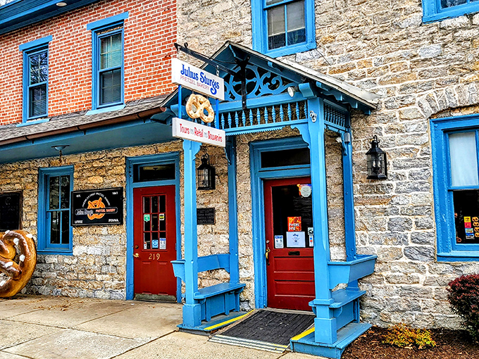 The iconic blue trim and stone facade of Julius Sturgis Pretzel Bakery stands as a delicious time capsule in downtown Lititz, welcoming pretzel pilgrims since the 19th century.