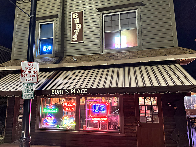 The unassuming exterior of Burt's Place glows with neon promise as night falls, a beacon for pizza pilgrims seeking caramelized crust nirvana.