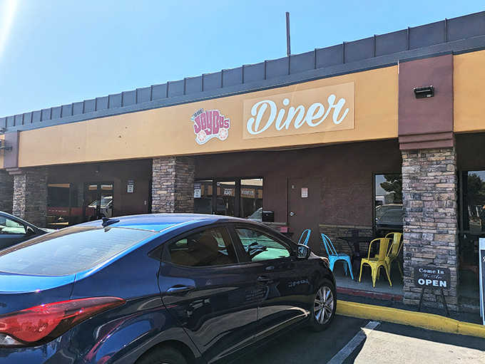 The sunny facade of The Joy Bus Diner welcomes hungry visitors with its cheerful signage and stone accents &ndash; a beacon of breakfast bliss in Phoenix.