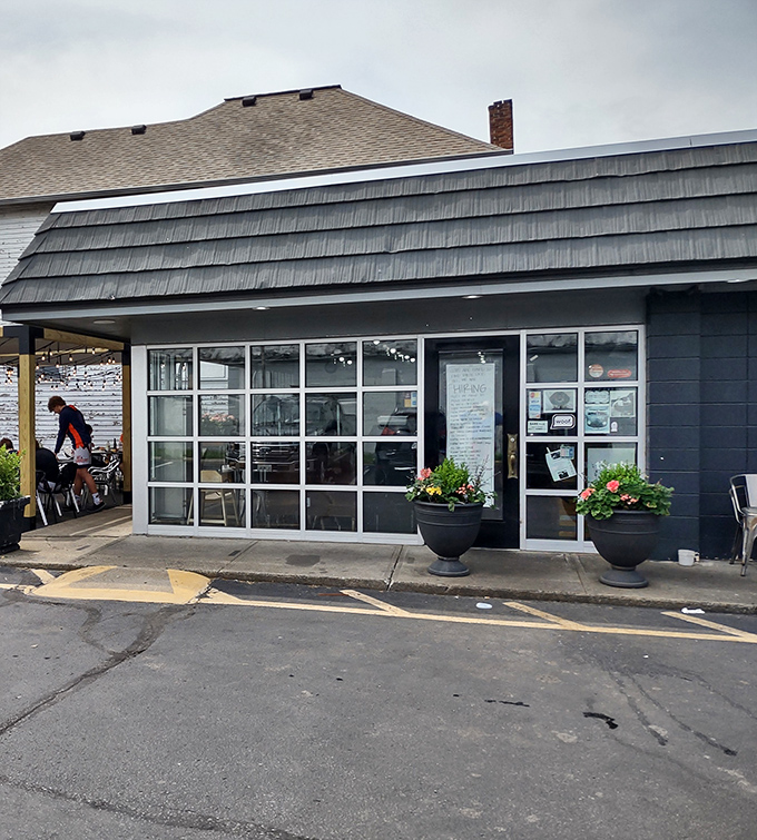 Blue-gray siding, elegant planters, and garage-door windows create an inviting facade that whispers "come in" rather than shouts it.