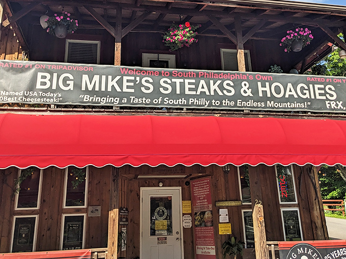 The wooden facade and bright red awning of Big Mike's stands like a beacon of hope for hungry travelers in the Endless Mountains.