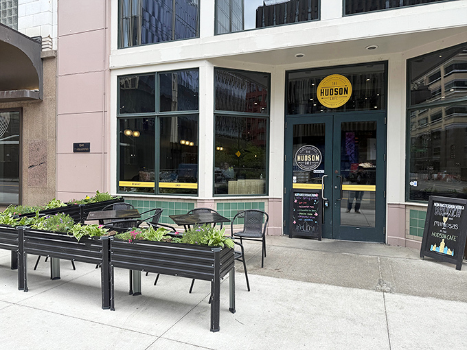 The Hudson Cafe's welcoming exterior beckons downtown Detroit diners with its clean lines and inviting patio seating, a breakfast oasis amid urban bustle.