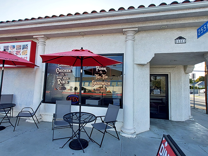 The unassuming exterior of Harry's Oklahoma Style Smokehouse BBQ proves once again that culinary treasures often hide in plain sight, with those red umbrellas beckoning meat lovers like a BBQ bat signal.