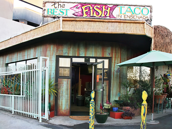 A colorful hand-painted sign welcomes taco pilgrims, featuring a fish with more personality than most Hollywood headshots.