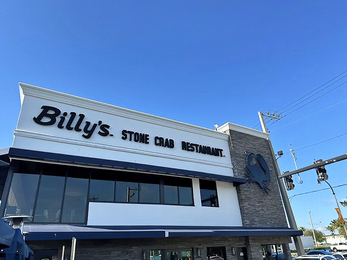 Billy's Stone Crab Restaurant stands proudly against the Florida sky, its iconic blue crab emblem promising seafood treasures within. Who knew steak perfection awaited behind those doors?