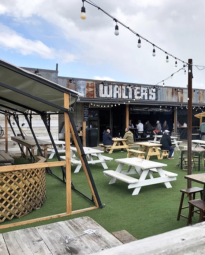 The entrance to Walter's BBQ beckons with rustic wooden beams, string lights, and that telltale stack of firewood promising smoky delights ahead.