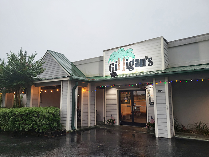 The welcoming facade of Gilligan's, where colorful string lights promise a warm escape even on rainy evenings. No wonder locals consider this their seafood sanctuary.