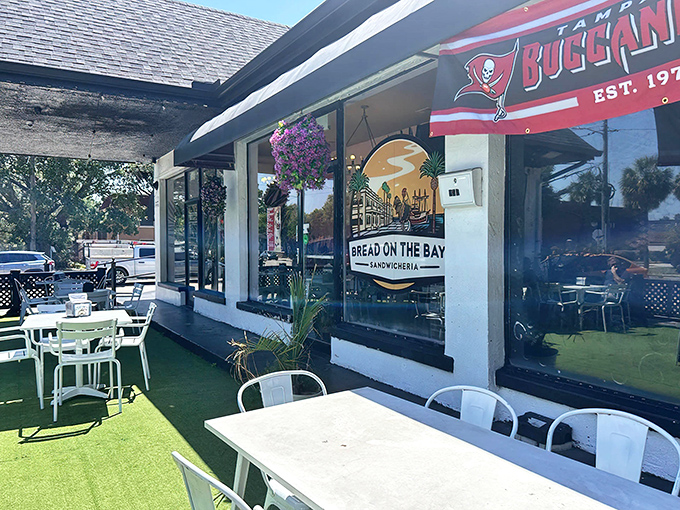 The perfect Florida sandwich oasis awaits with artificial turf, white chairs, and a Tampa Bucs flag proudly announcing its local roots.