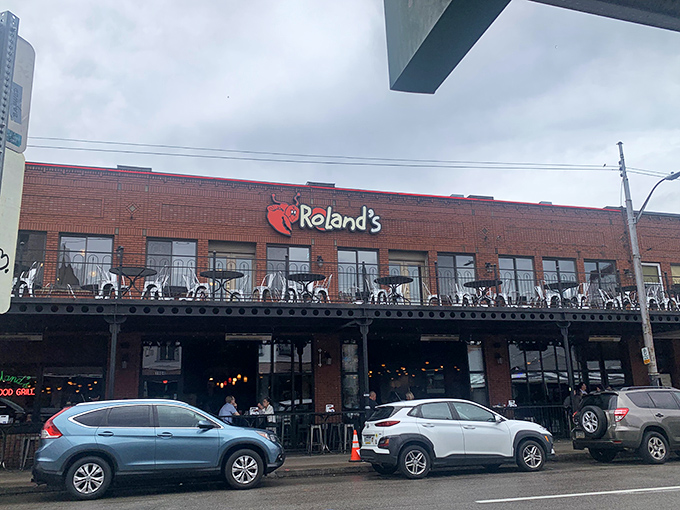 Roland's brick exterior with its cheerful lobster logo promises seafood salvation in Pittsburgh's vibrant Strip District.