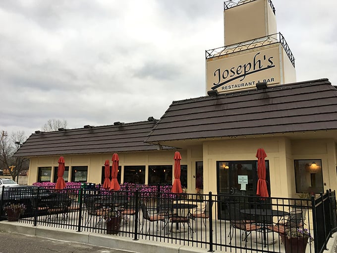 Joseph's distinctive sloped roof and welcoming patio stand like a beacon for hungry travelers. Those red umbrellas practically whisper, "Come sit a while."
