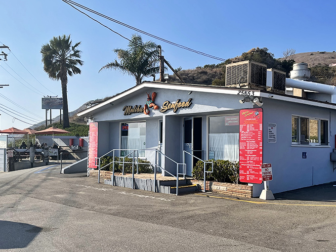 The unassuming white building with red trim might not scream "culinary destination," but locals know this PCH landmark houses seafood treasures worth any wait.