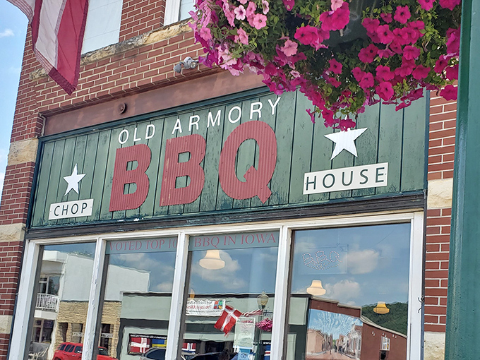 The green facade with vibrant pink flowers says "serious about meat, but we still appreciate beauty." A BBQ beacon in downtown Decorah.