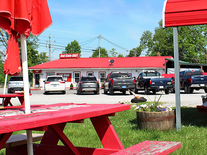 Red picnic tables await beneath umbrellas, promising the kind of outdoor dining experience where sauce on your shirt is a souvenir, not an accident.