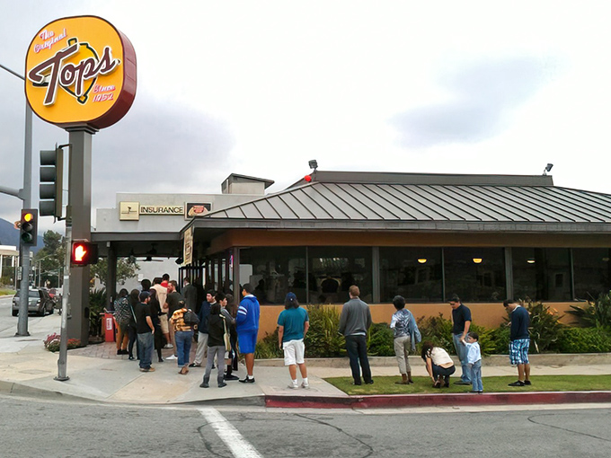 The iconic yellow Tops sign beckons hungry Pasadenans like a culinary lighthouse, with a line that speaks volumes about what awaits inside.