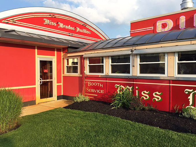 The classic red exterior of Miss Mendon Diner gleams like a beacon of breakfast hope along Route 16, promising "Booth Service" and morning happiness.