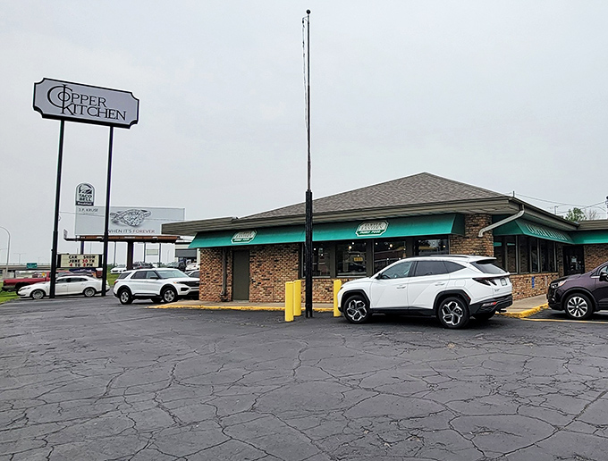 The unassuming brick exterior of Copper Lantern stands like a beacon of breakfast hope in St. Cloud, those green awnings promising comfort within.