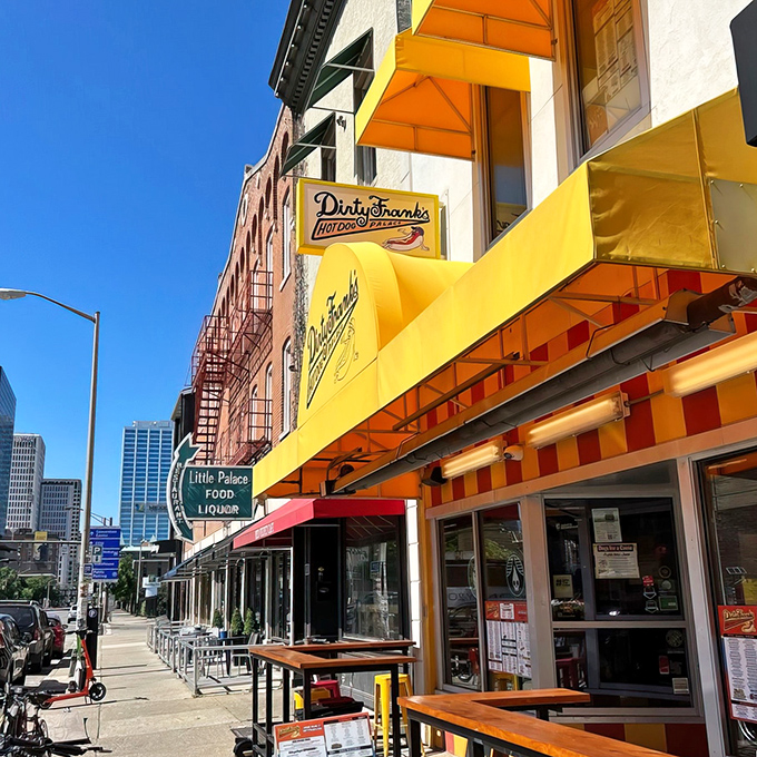 The iconic yellow and red striped awning of Dirty Frank's beckons like a hot dog lighthouse in Columbus's urban landscape. Resistance is futile.