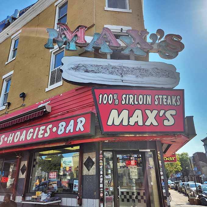 The iconic Max's Steaks sign glows like a neon North Star for sandwich pilgrims, promising "100% SIRLOIN STEAKS" with all the subtlety of a Philly sports fan.