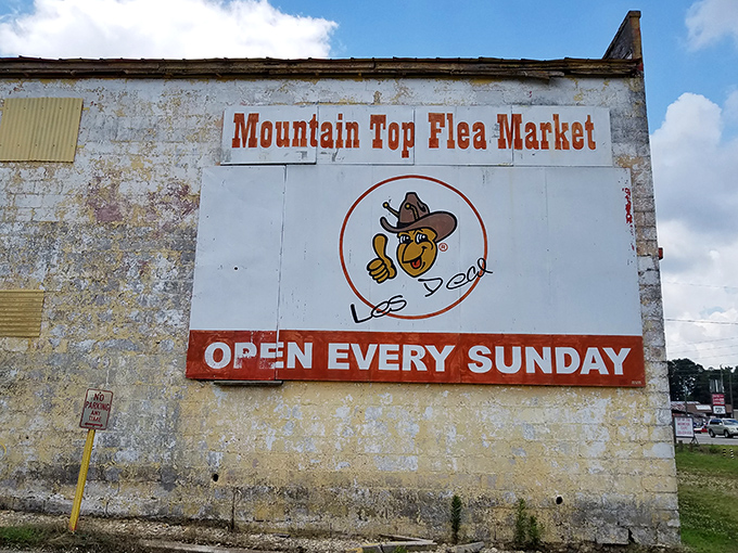The weathered sign with its cheerful cowboy mascot stands as a beacon of Sunday treasure hunting, promising adventures that money can't buy&mdash;but bargains you can.