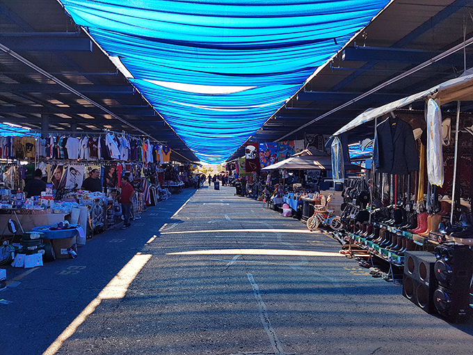 Beneath azure tarps that filter desert sun into cool blue light, shoppers navigate this covered bazaar like seasoned explorers on a quest for deals.