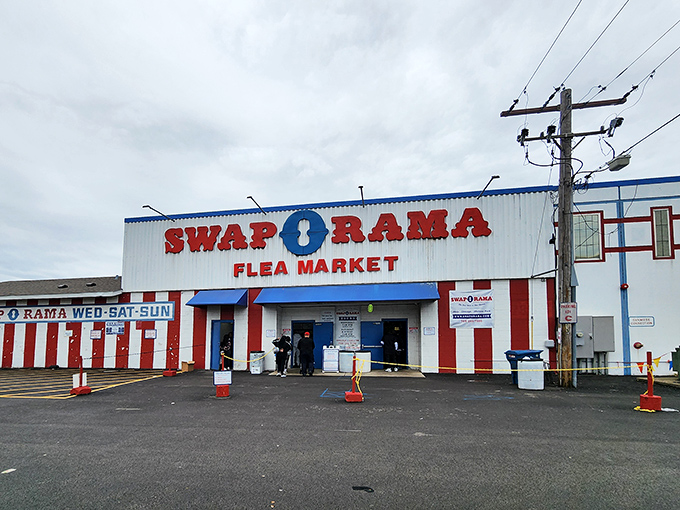The iconic red and white striped entrance to Swap-O-Rama stands like a carnival barker promising treasures within. Step right up to bargain paradise!